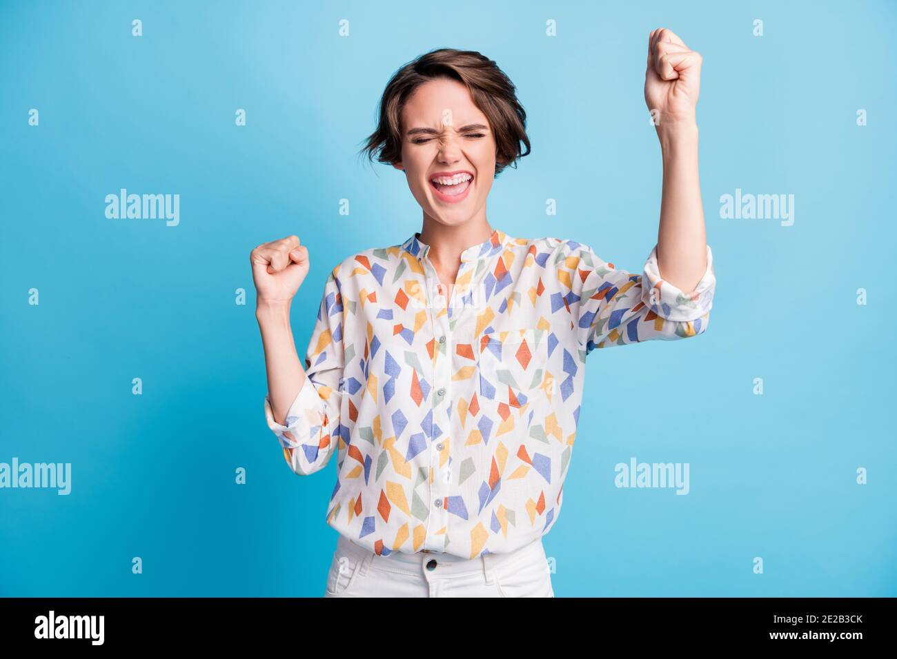 Photo of charming pretty lucky young lady raise fists closed eyes wear ...