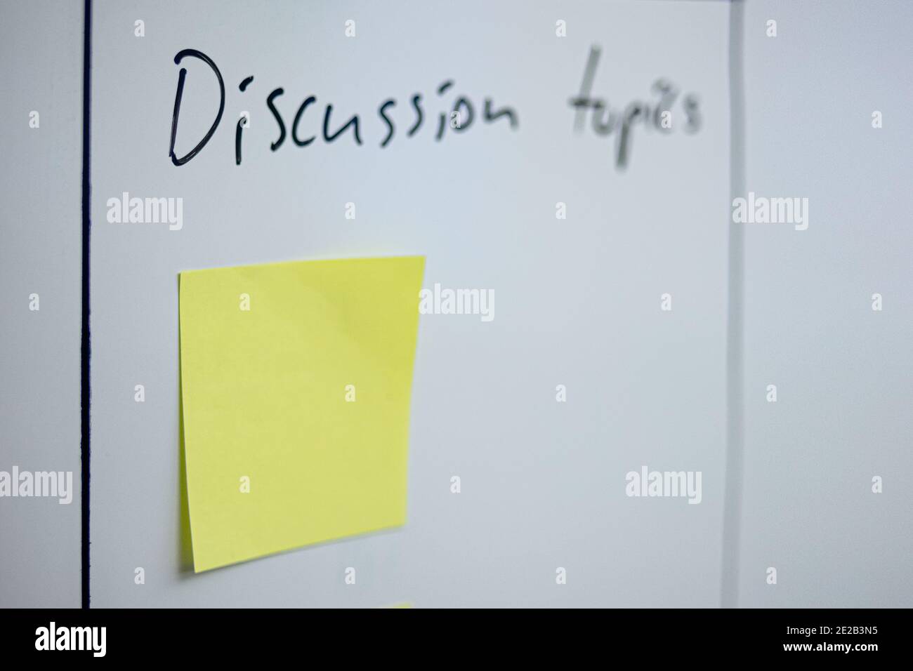 Yellow sticker on the whiteboard with discussion topics label Stock ...