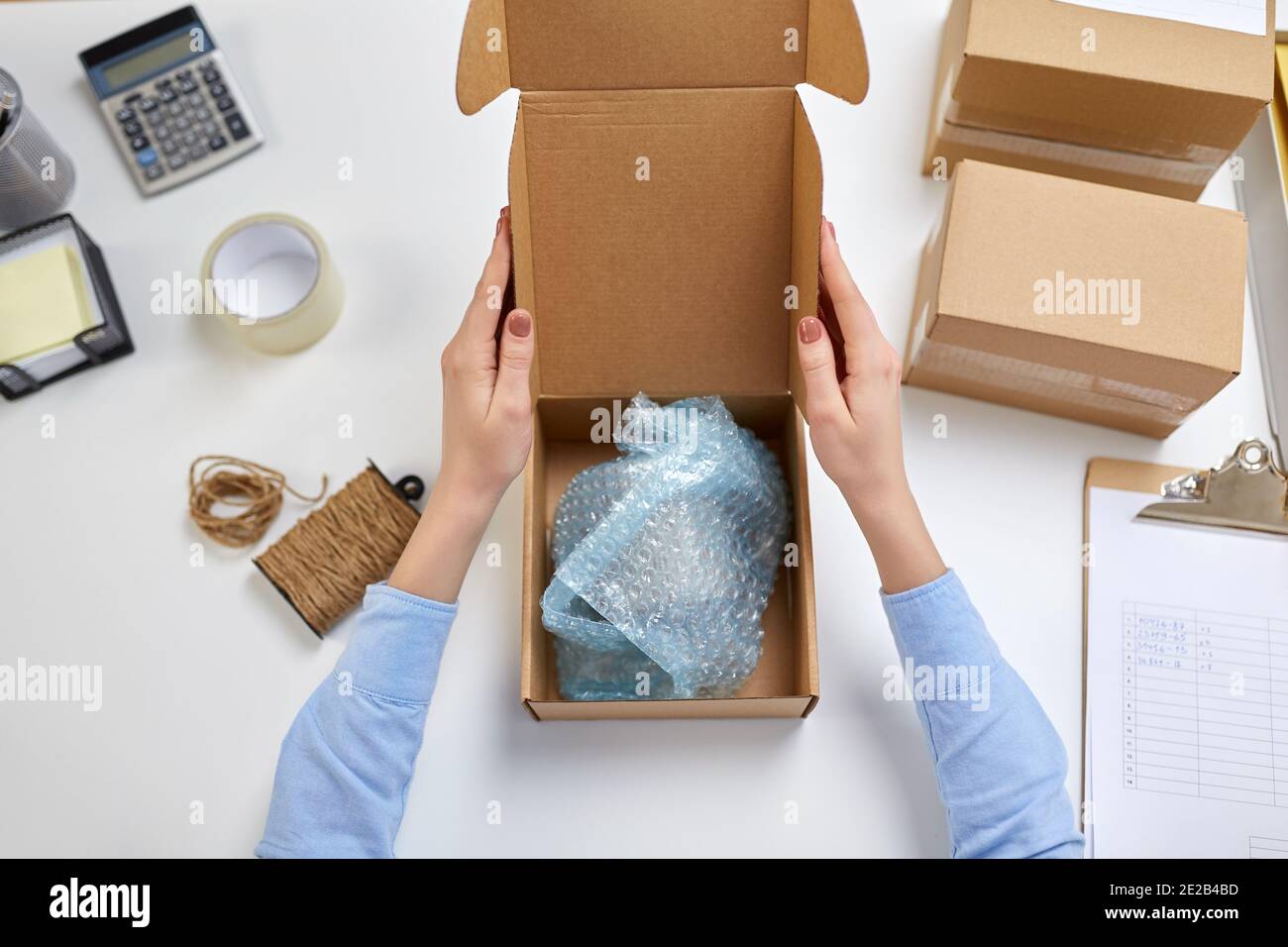 hands packing mug to parcel box at post office Stock Photo - Alamy