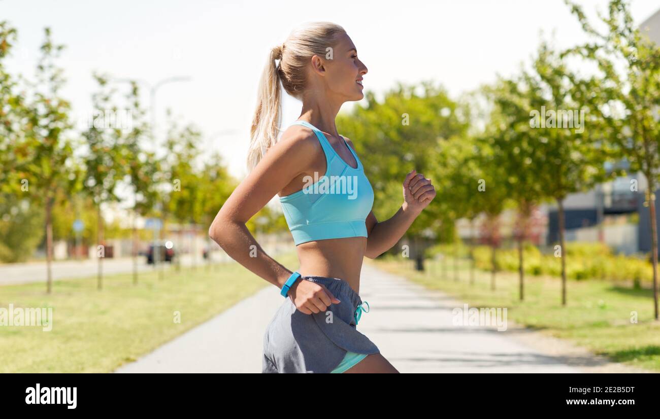 smiling young woman running outdoors Stock Photo - Alamy