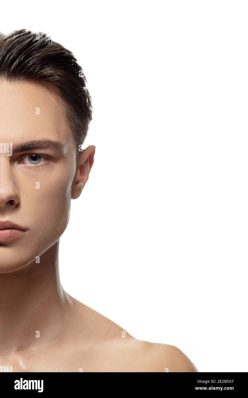 Half-face. Portrait of young man isolated on white studio background ...