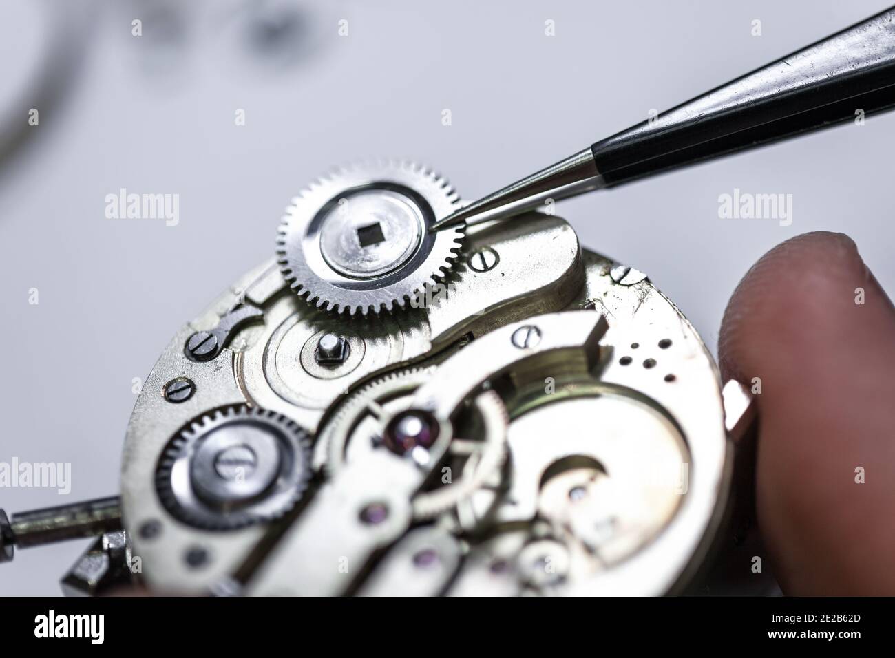Closeup shot of a craftsman fixing gears on a clock Stock Photo - Alamy
