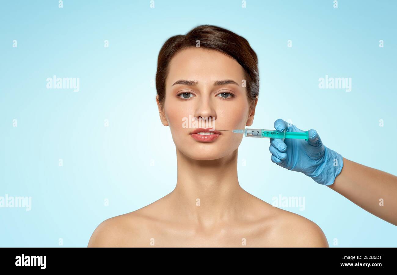 beautiful young woman and hand with syringe Stock Photo - Alamy