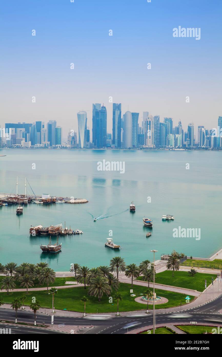 Qatar, Doha, Traffic at roundabout, West Bay skyscrapers in background ...