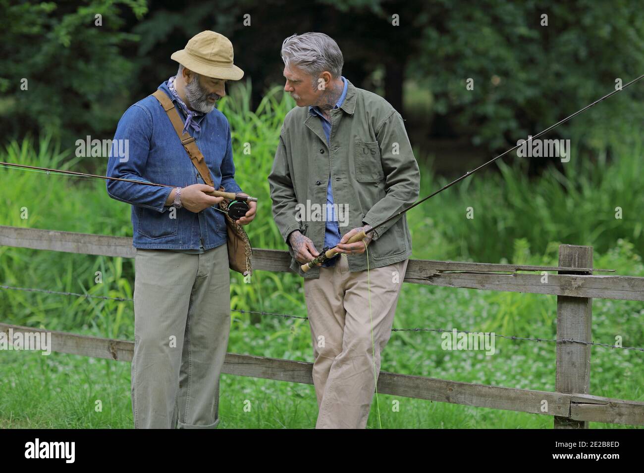 Two male friends standing with his friend and explaining how setting up ...