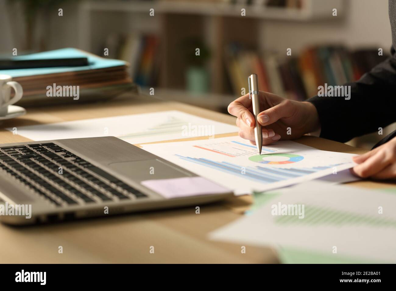 Close up of entrepreneur hand working in the night checking paper chart ...