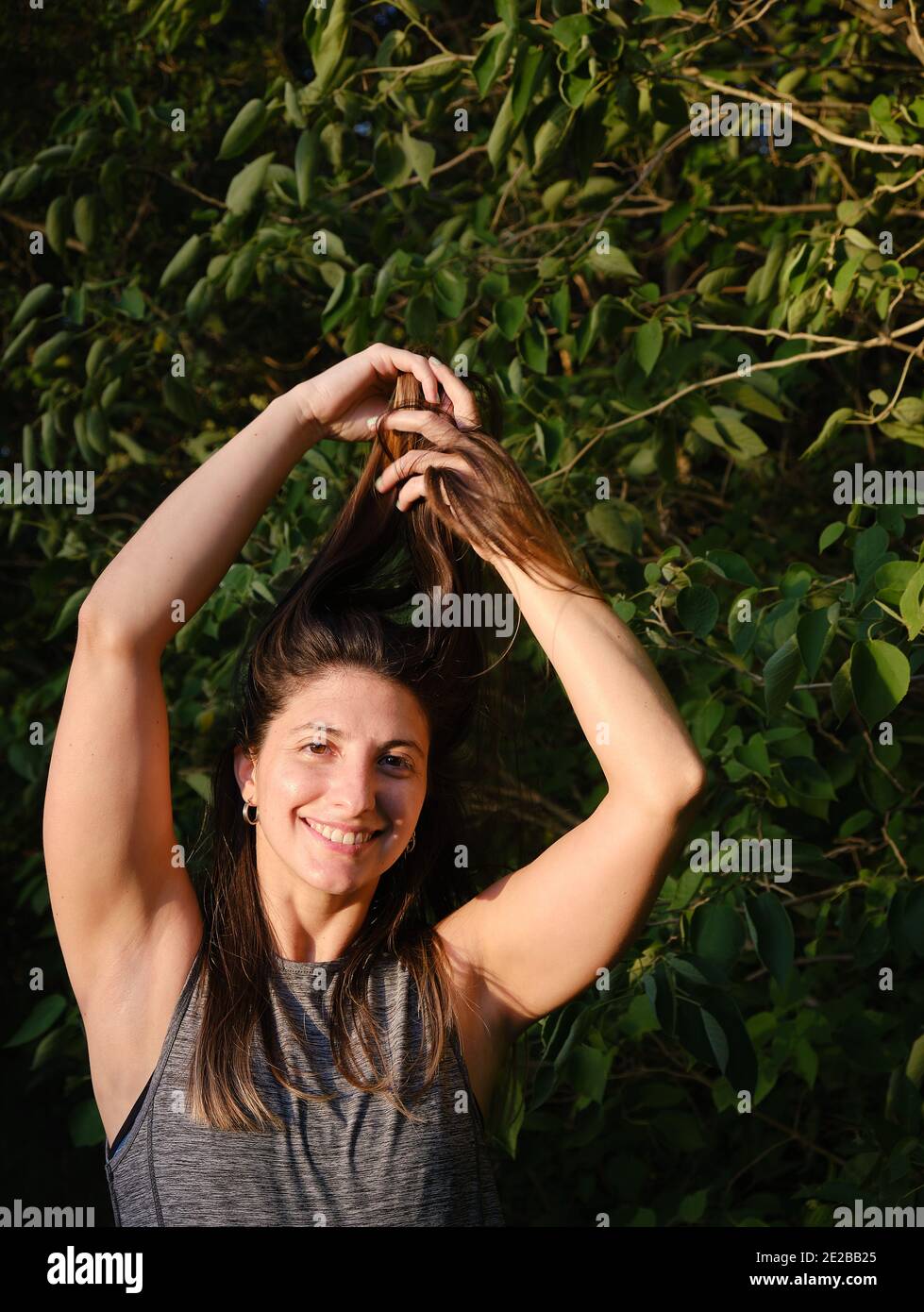 a portrait of a woman model grabbing her hair in the forest Stock Photo ...