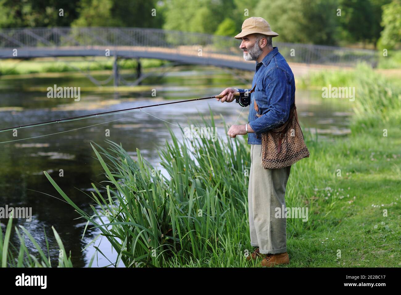 Fly angler fly fishing in lake Stock Photo - Alamy