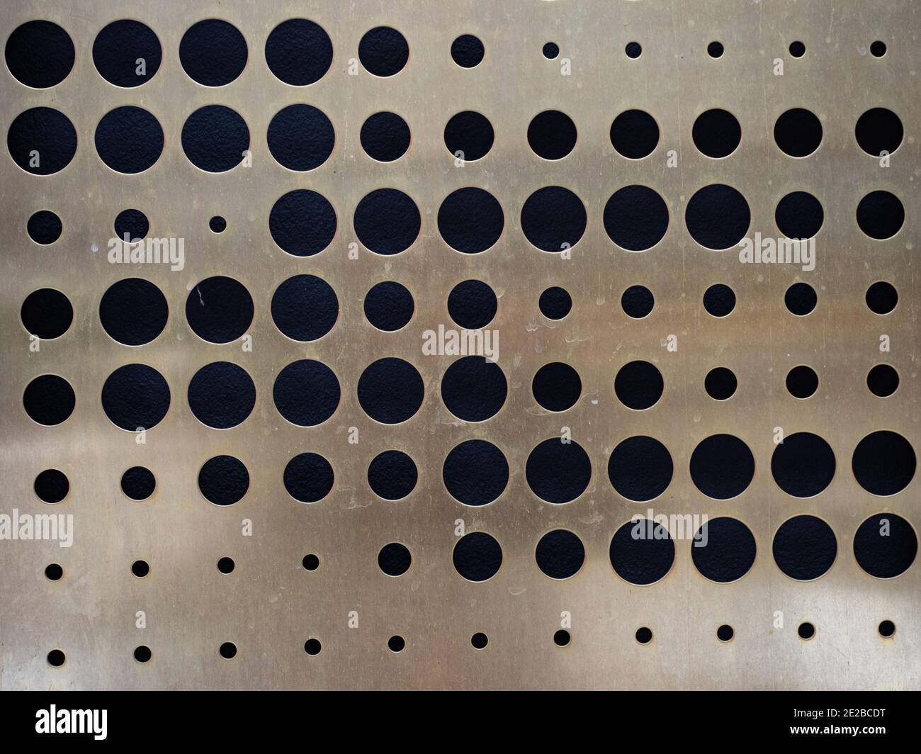 Background, texture. Metal wall with round holes of different sizes ...