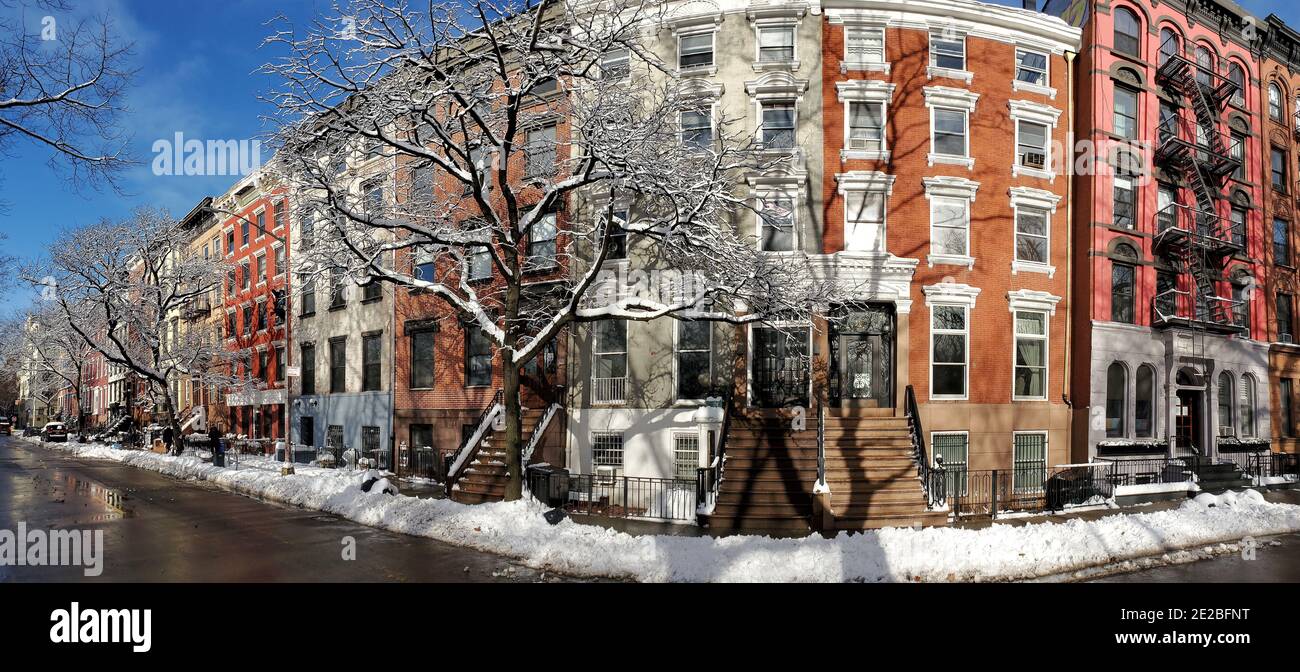 Sun shines on a snow covered block of colorful buildings along 10th ...