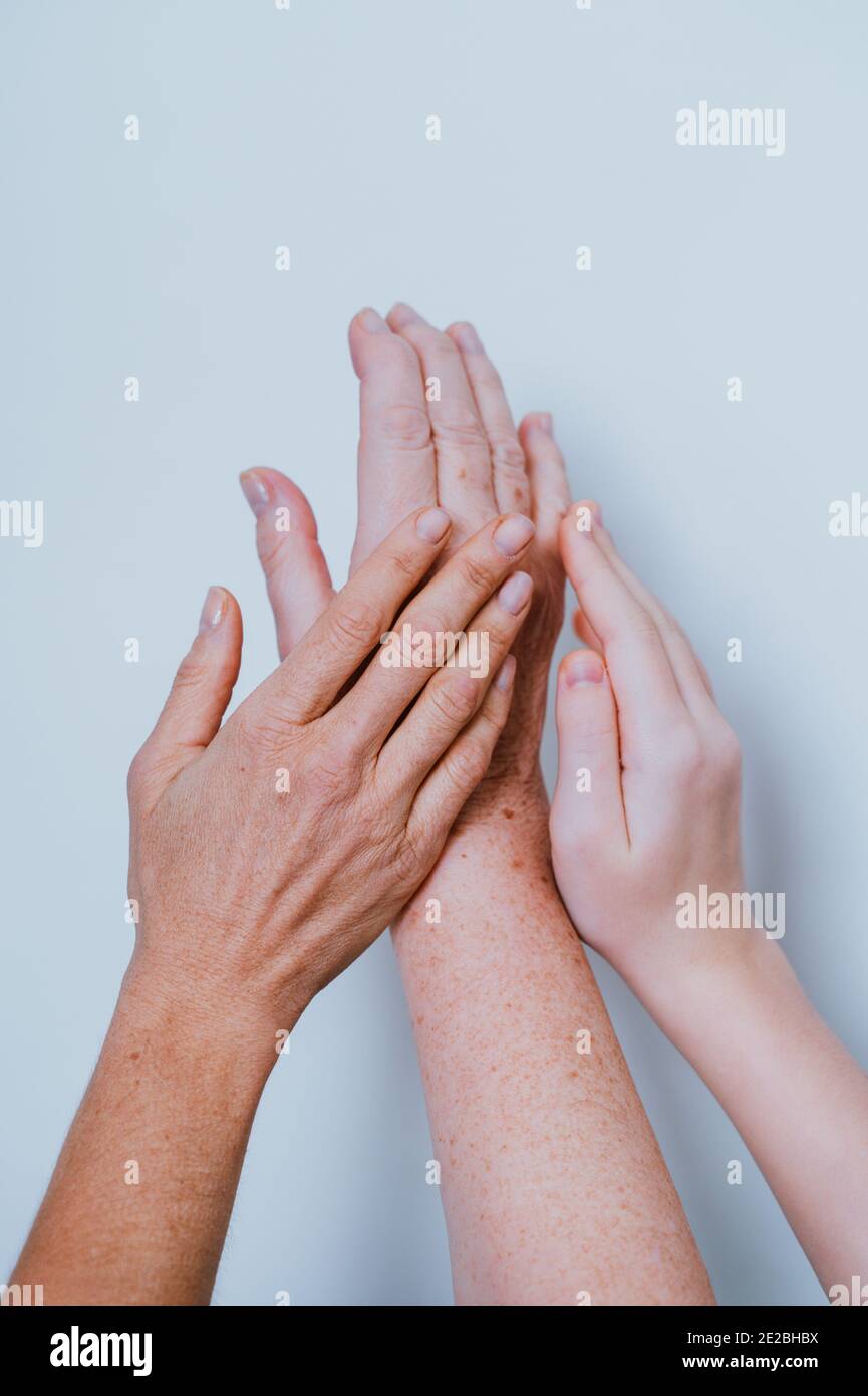 Image of three hands touching each other. Grandmother, daughter and ...
