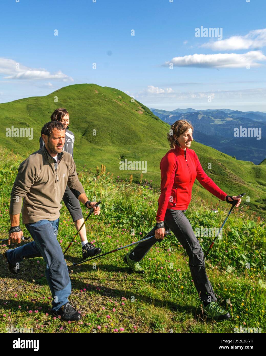 Sporty young people doing a Nordic Walking session in alpine nature ...
