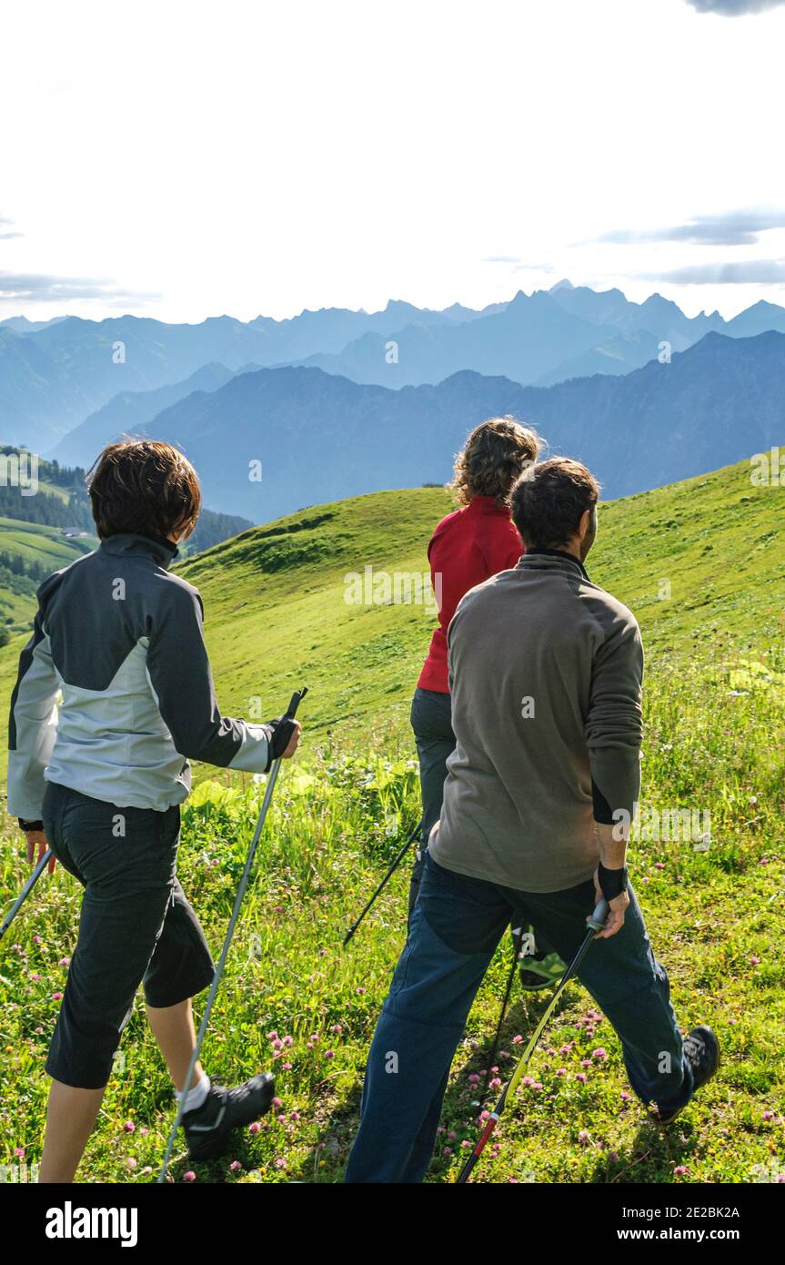 Sporty young people doing a Nordic Walking session in alpine nature ...
