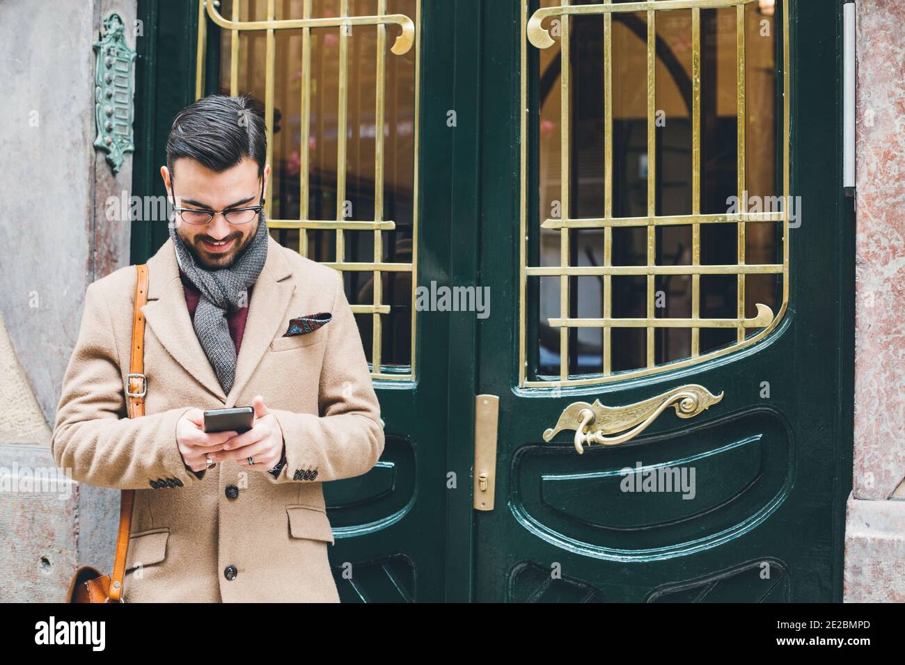 Elegant young man in dandy style fashion using the smart phone on the ...