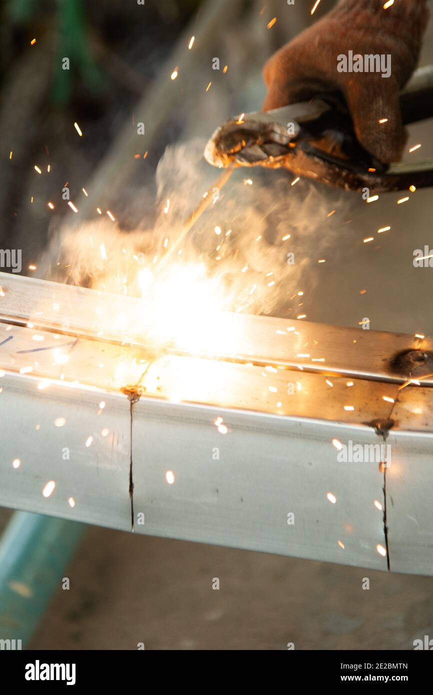 Welders weld metal fences by welding machines Stock Photo - Alamy