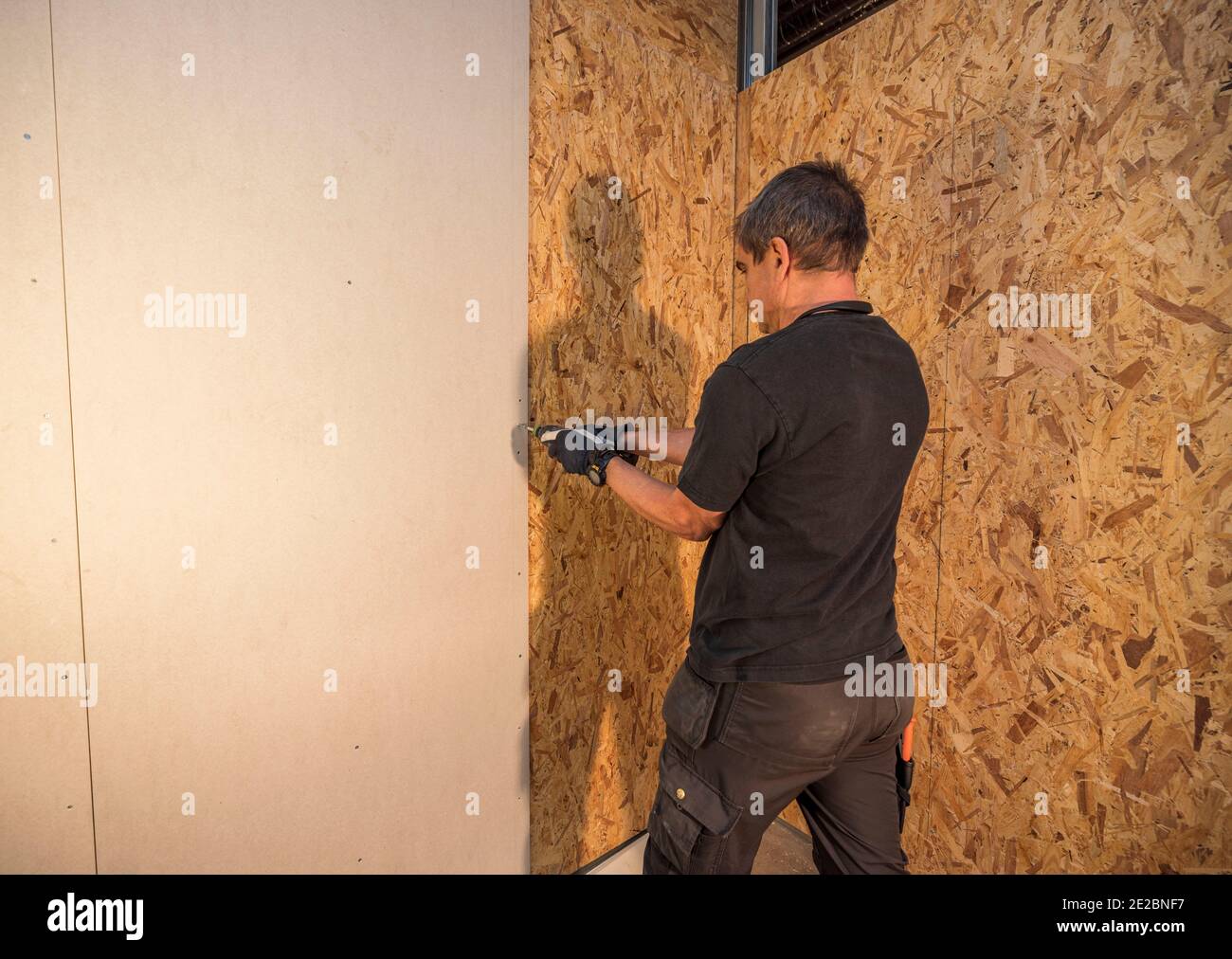 Close up view of worker building interior partition wall. Construction ...