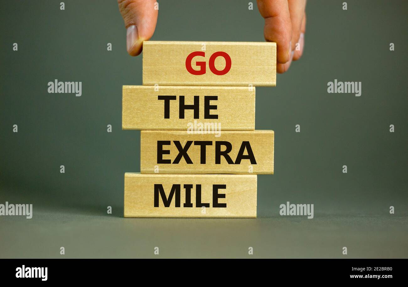 Go the extra mile symbol. Wooden blocks with words 'Go the extra mile ...