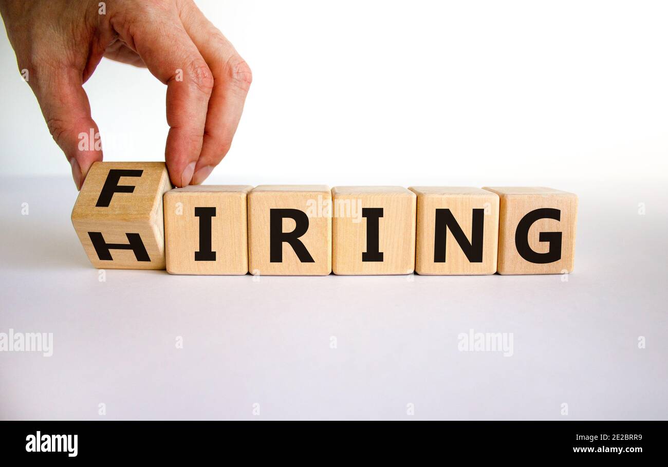 Hiring or firing symbol. Businessman hand turns a wooden cube and ...