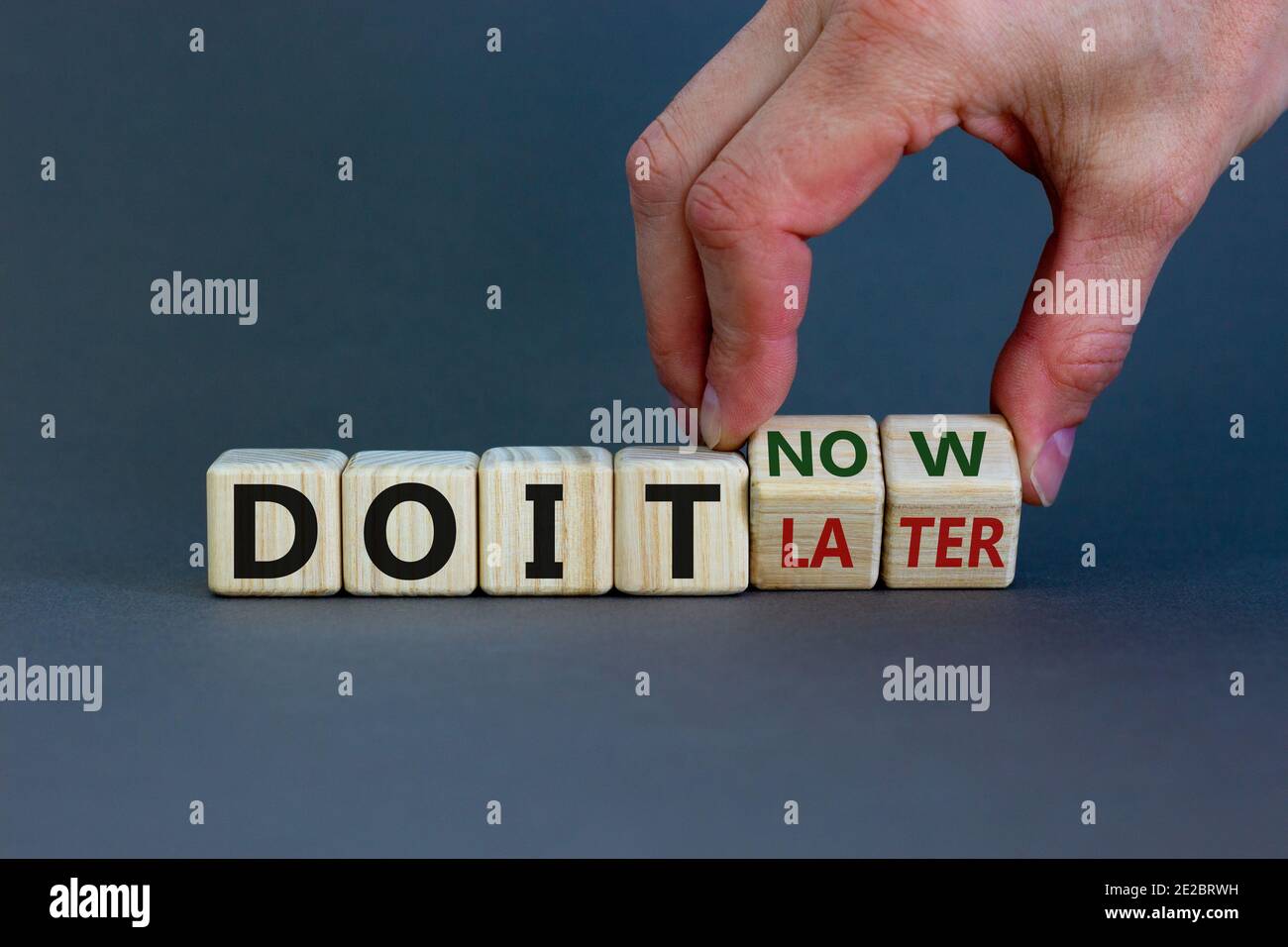 Do it now symbol. Businessman hand turns cubes and changes words 'do it ...