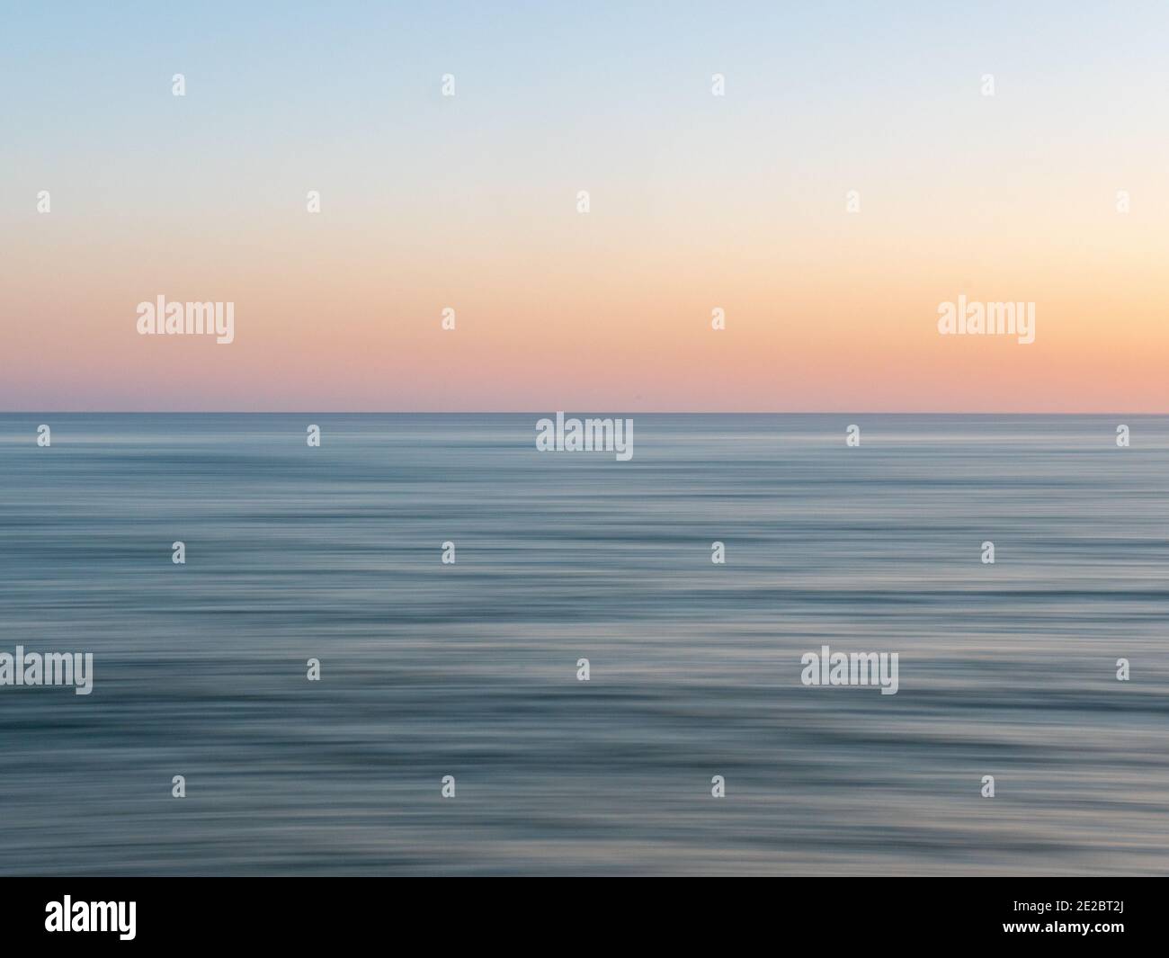 Idyllic view of the ocean with the clear skyline at sunset Stock Photo ...