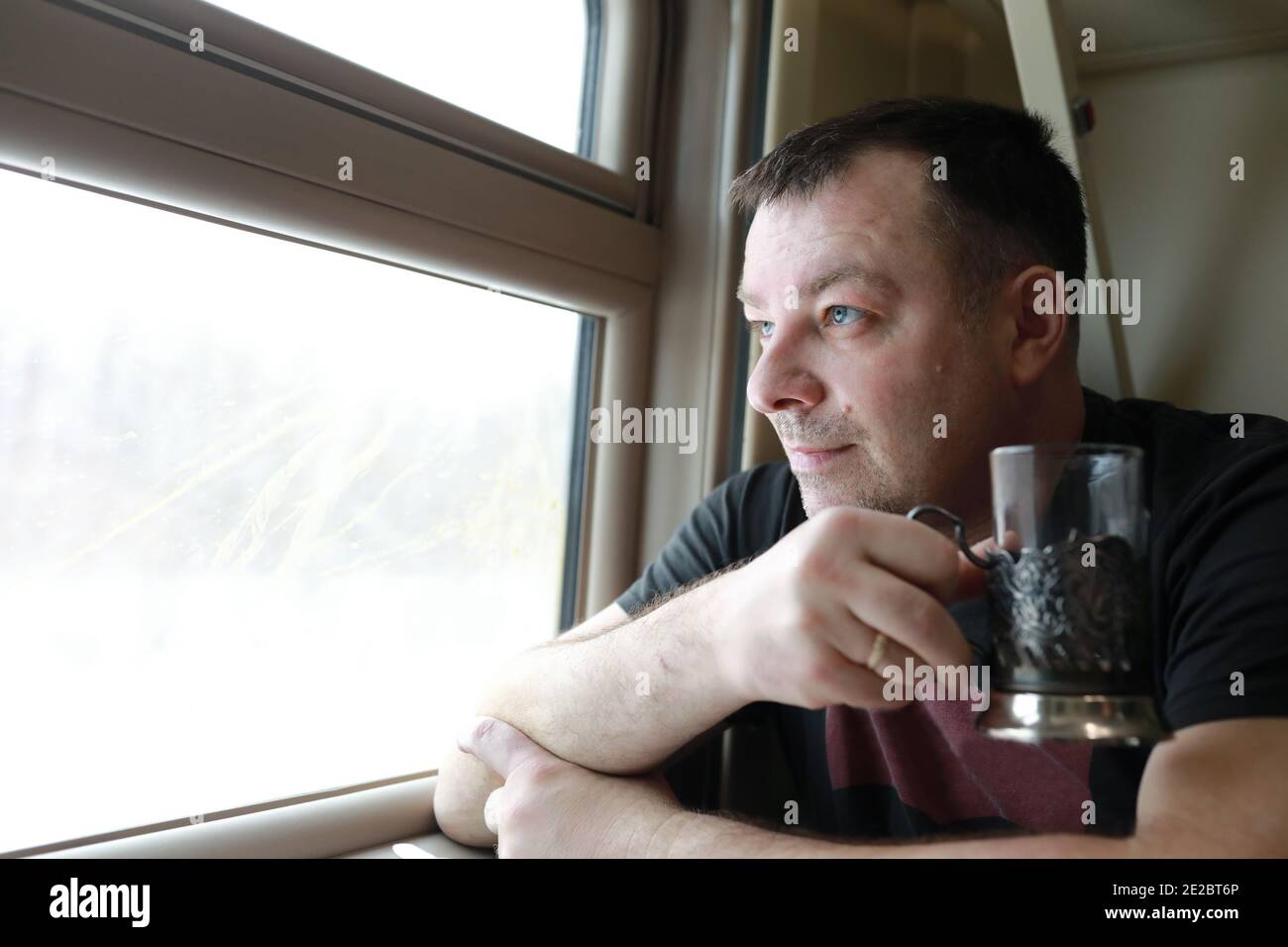 Man drinking tea in train next to window Stock Photo - Alamy