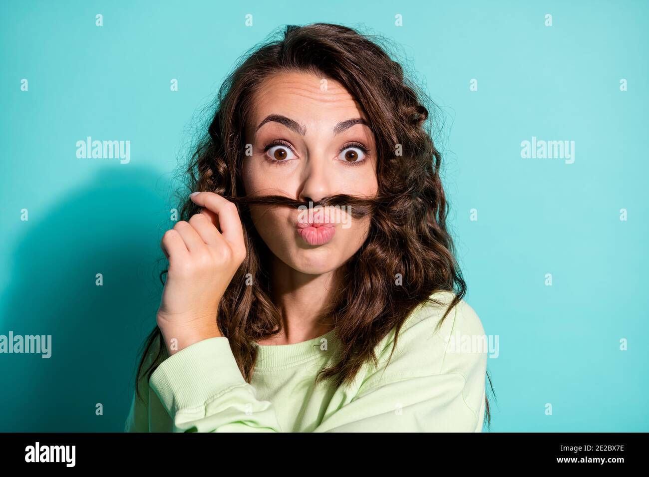 Photo of funky pretty girl cover face with curl wear green sweater ...