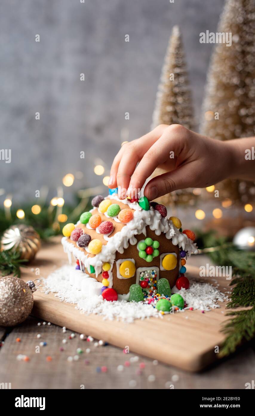 Child's hand picking candy off of a decorated gingerbread house Stock ...