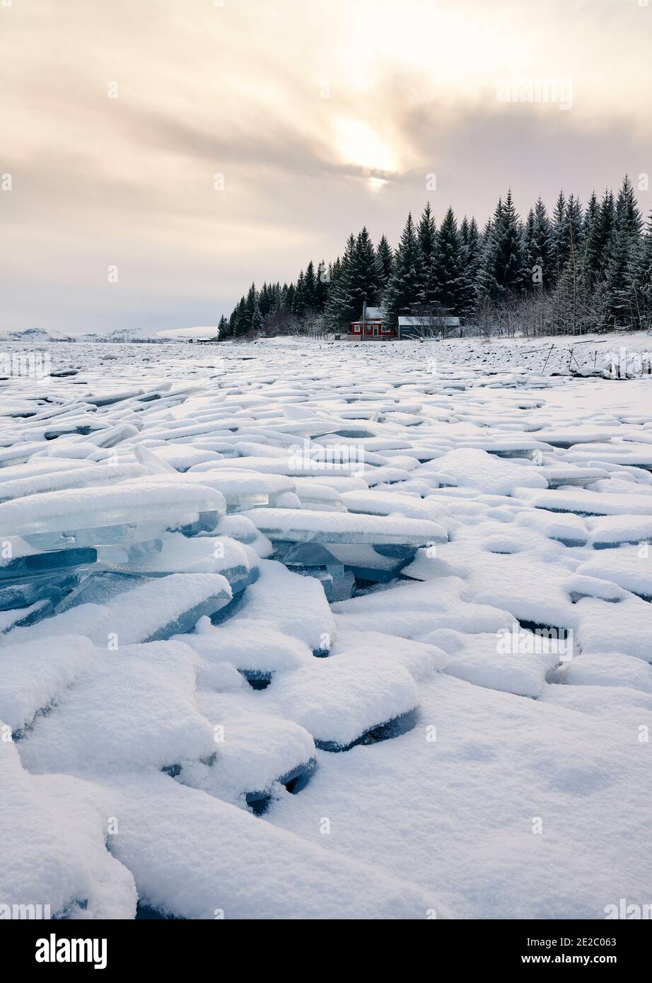 Rough ice formations covered with snow on surface of frozen lake near ...