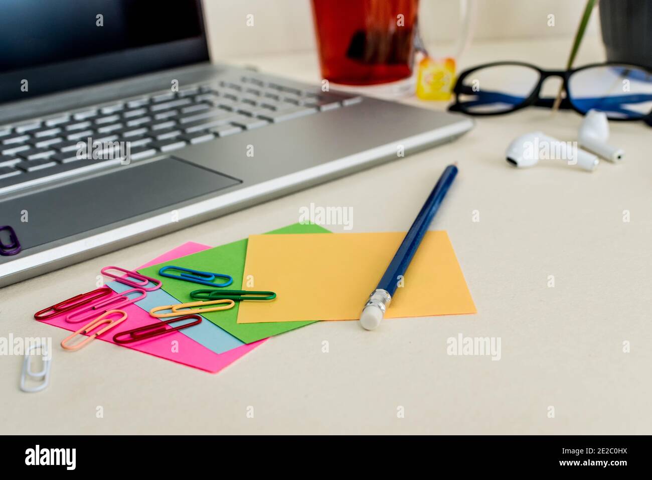 Closeup of colorful notes with paper clips, headphones, laptop, and a ...
