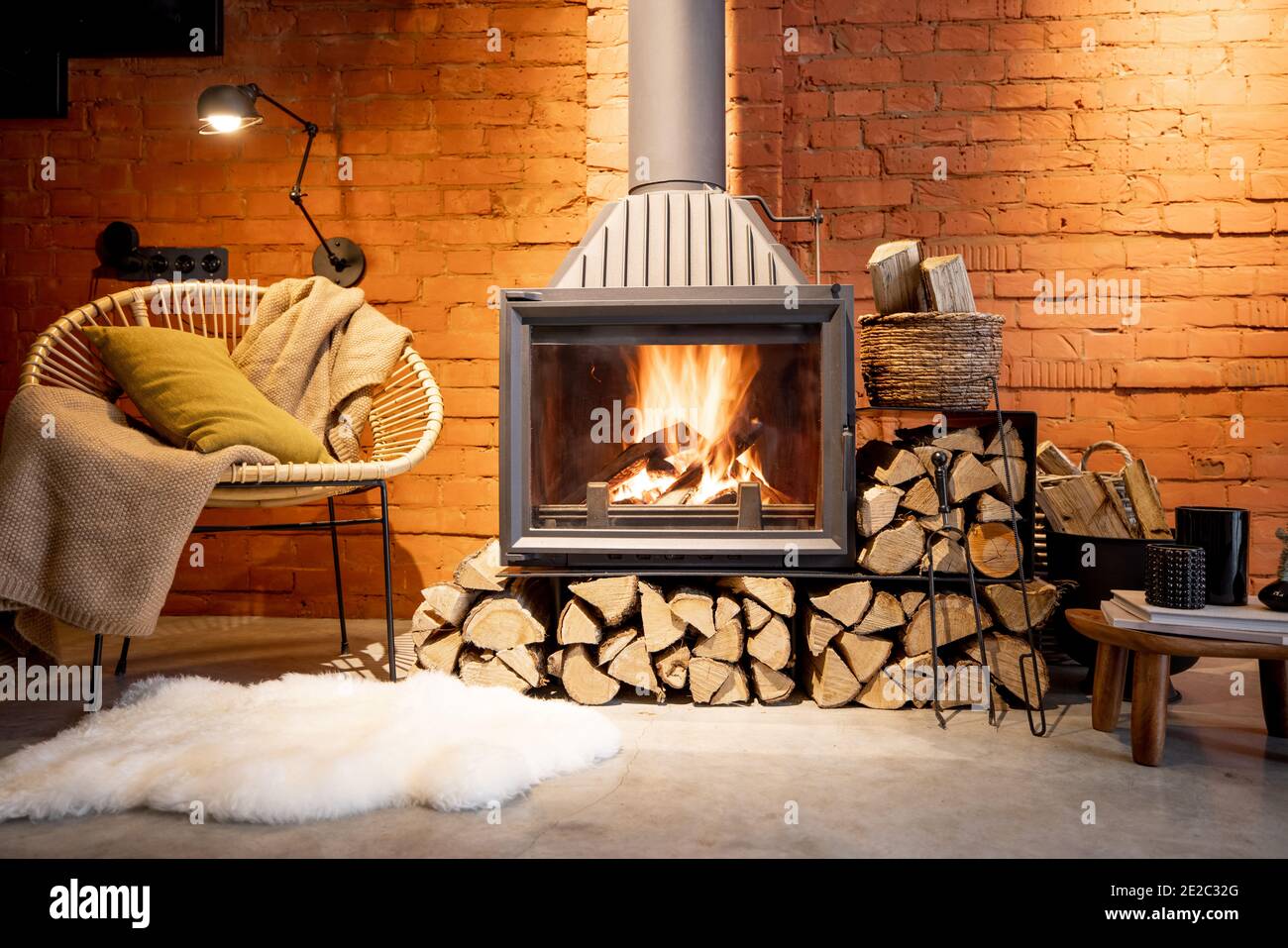 Cozy fireplace with firewood in the loft style home interior with brick ...
