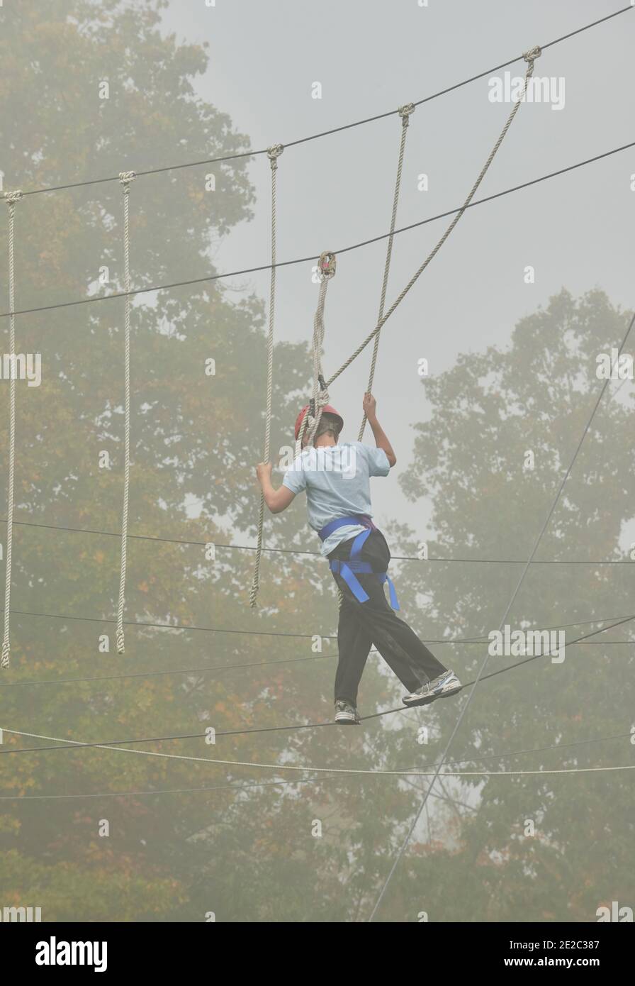 High Ropes Experience at school camp. Student crossing guide wires ...