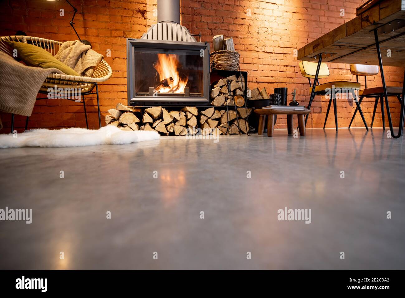 Cozy fireplace with firewood in the loft style home interior with brick ...