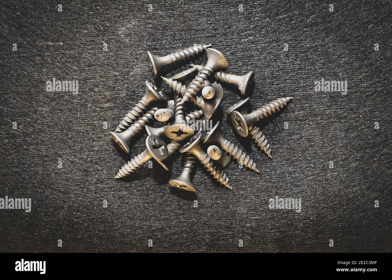 black metal screws on a black background Stock Photo - Alamy
