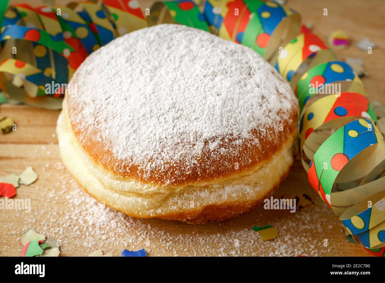 Donut with colorful paper snakes and confetti Stock Photo - Alamy