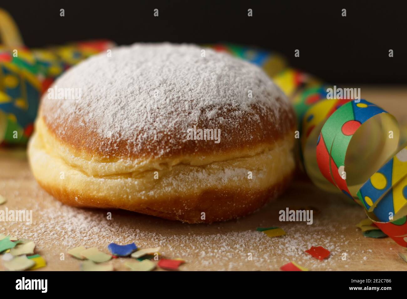 Donut with colorful paper snakes and confetti Stock Photo - Alamy