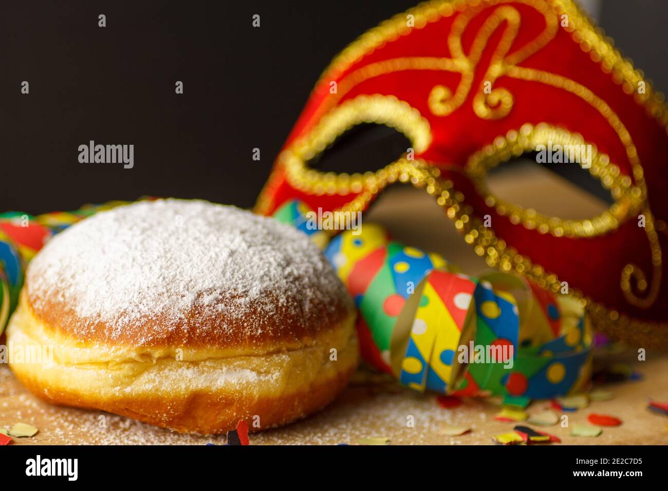 Donut with colorful paper snakes and confetti Stock Photo - Alamy