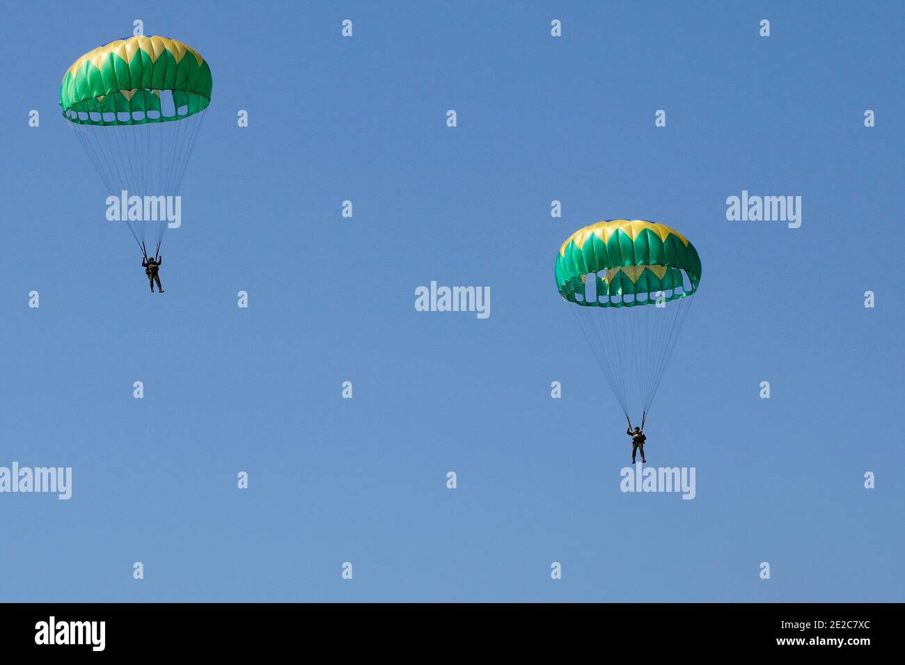 Military army parachutes paratroopers jump in blue sky from airplane ...