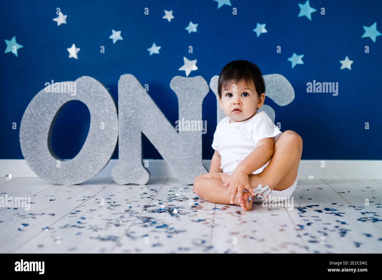 One year old baby boy in white t-shirt celebrates birthday near silver ...