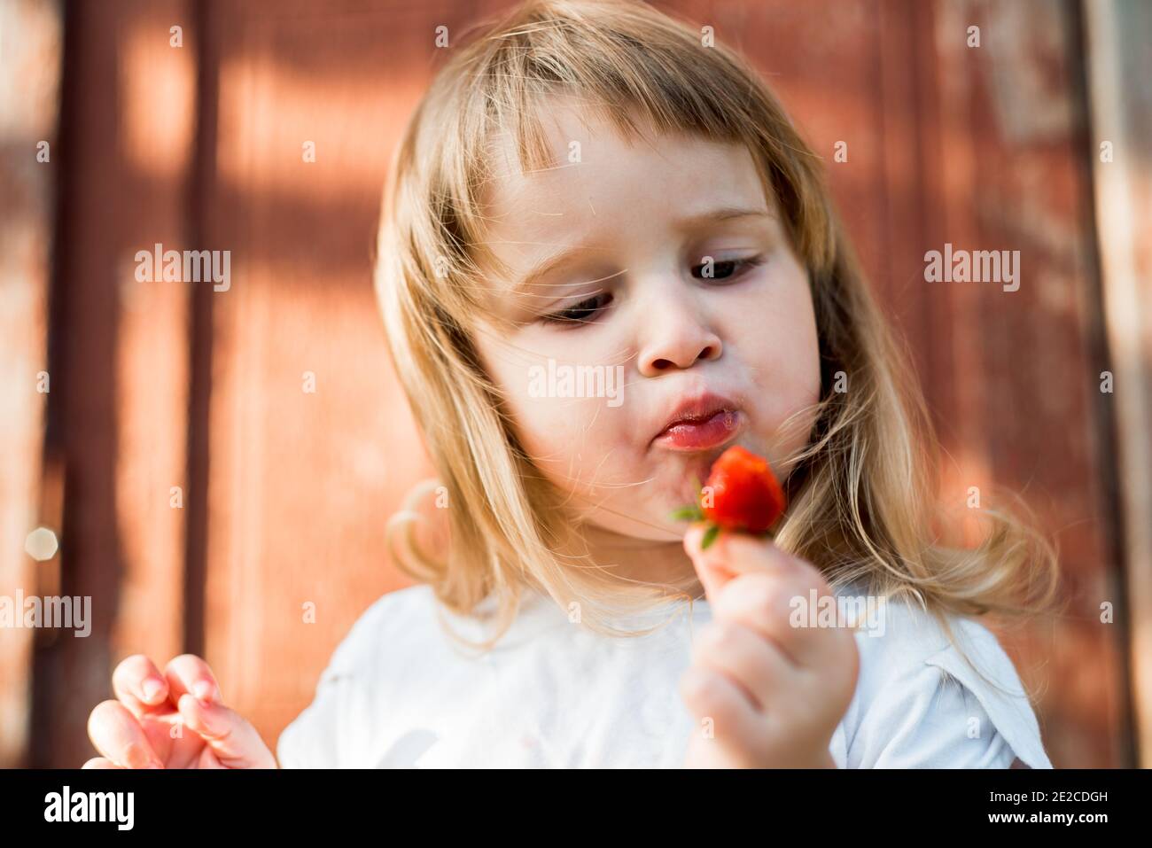 Girl eats strawberry hi-res stock photography and images - Alamy