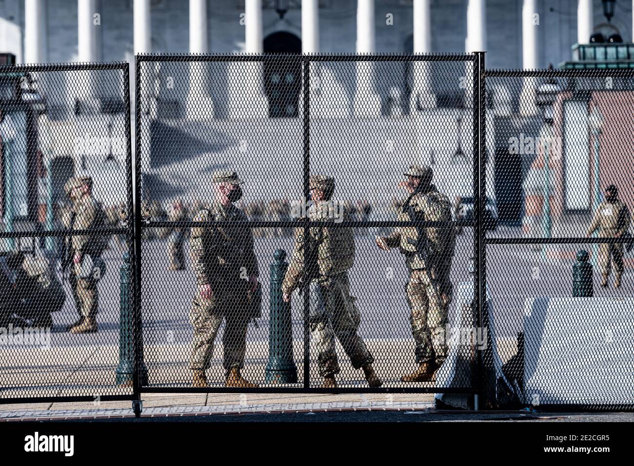 National Guard troops standing guard by non-scalable fencing that was ...