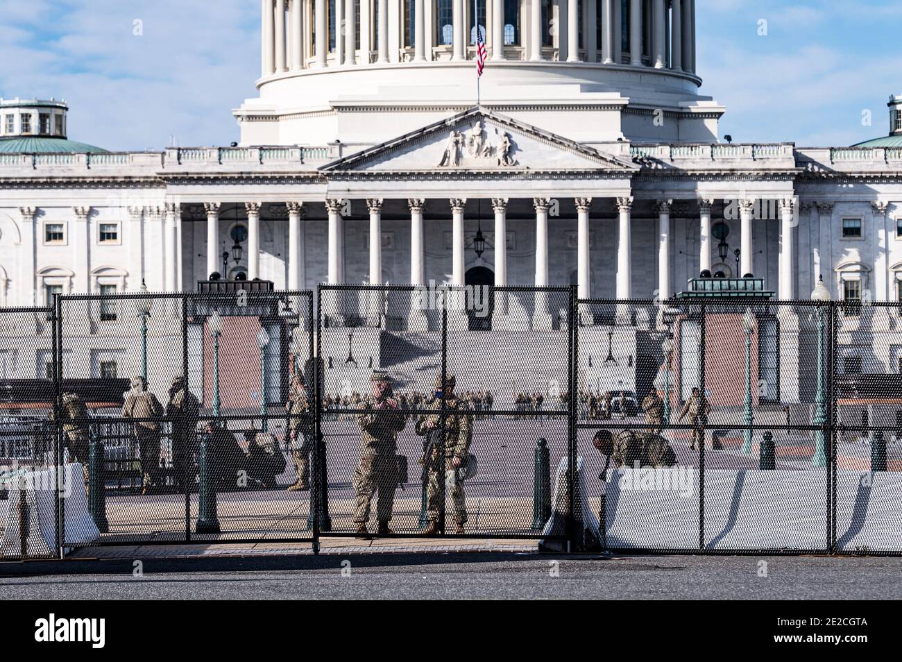 National Guard troops standing guard by non-scalable fencing that was ...