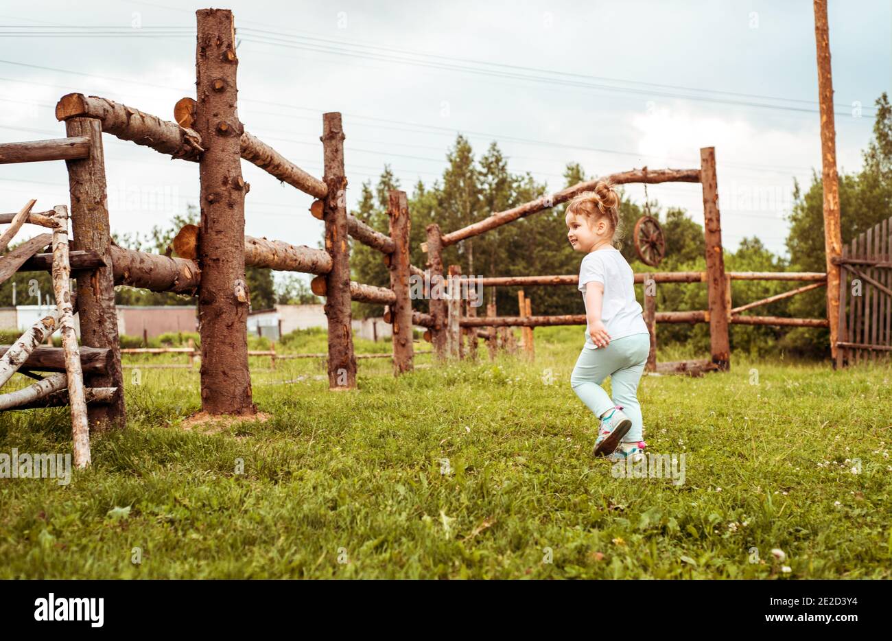 Lifestyle, baby girl running about the wooden fence, summer day on the ...