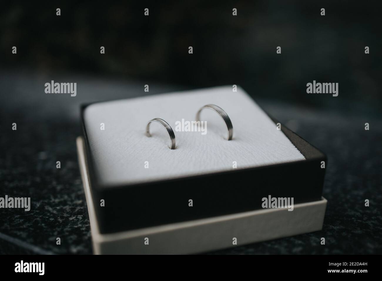 Close up shot of two wedding rings in a box on a bl Stock Photo - Alamy