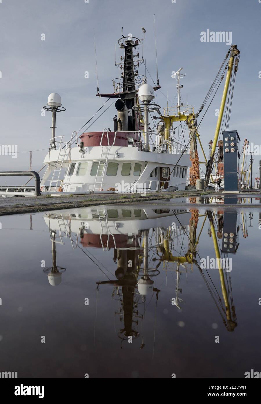 Vertical shot of the reflection of a sailing boat on the water on the ...