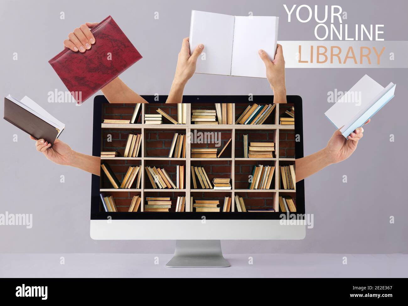 Hands holding books through screen of computer monitor on grey ...