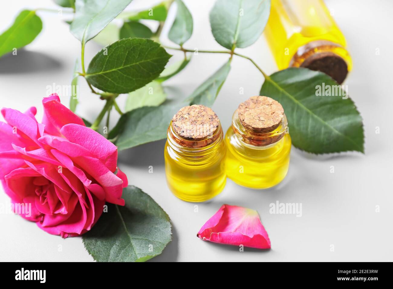 Bottles with floral essential oil on light background Stock Photo - Alamy