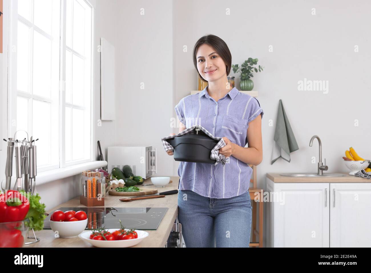 Beautiful young woman cooking dinner in kitchen Stock Photo - Alamy