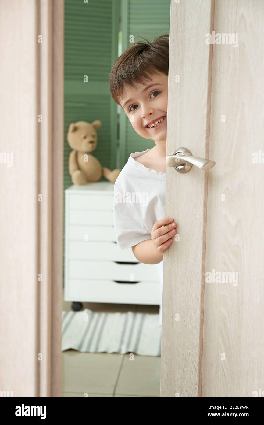 Cute little boy looking out the door Stock Photo - Alamy