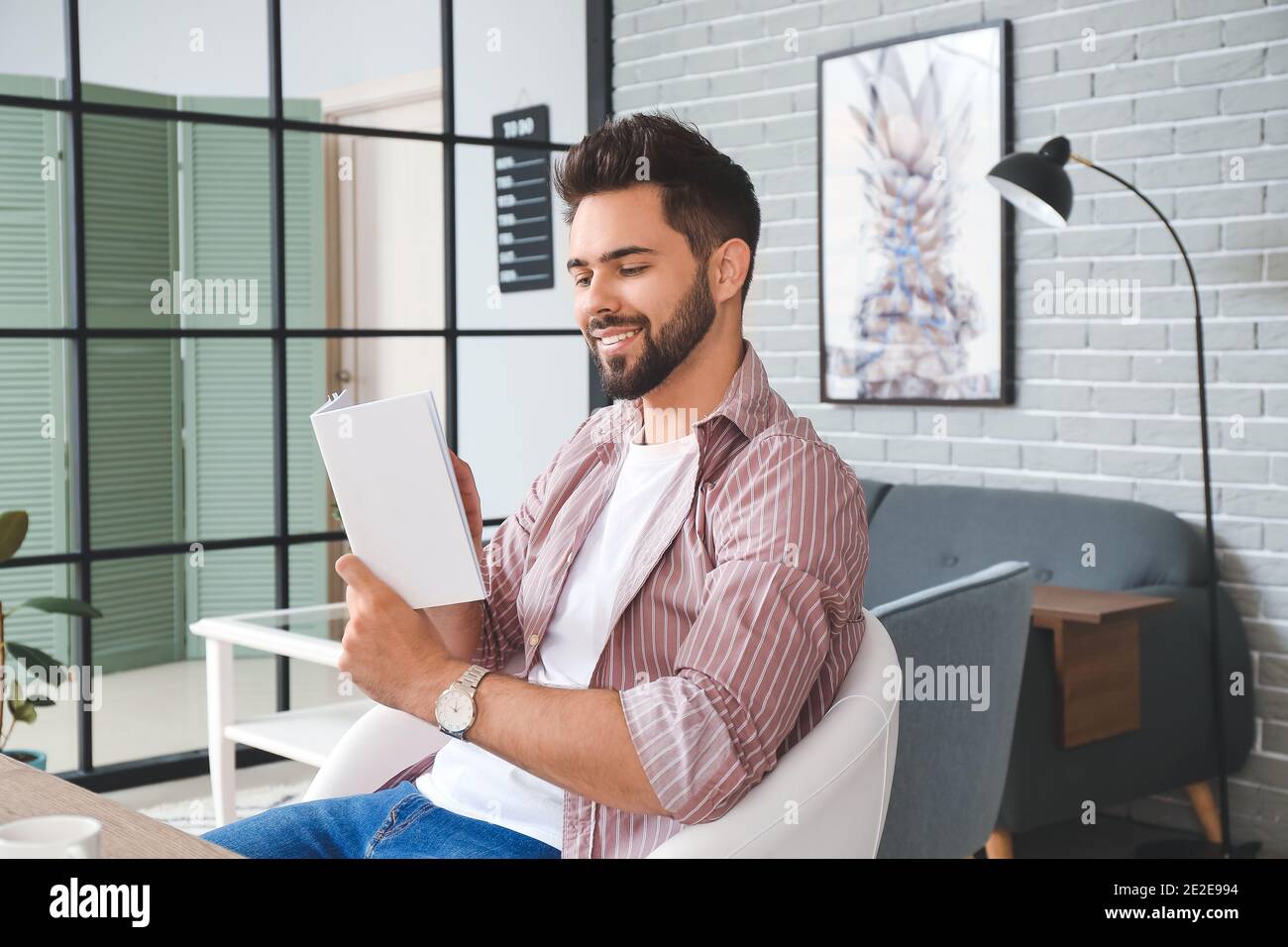 Young man reading magazine at home Stock Photo - Alamy