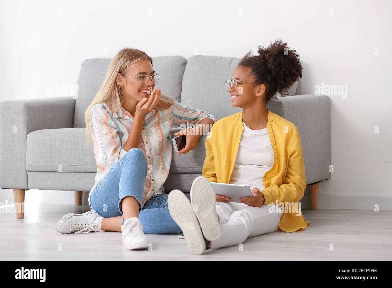 Teenage girls with different devices at home Stock Photo - Alamy